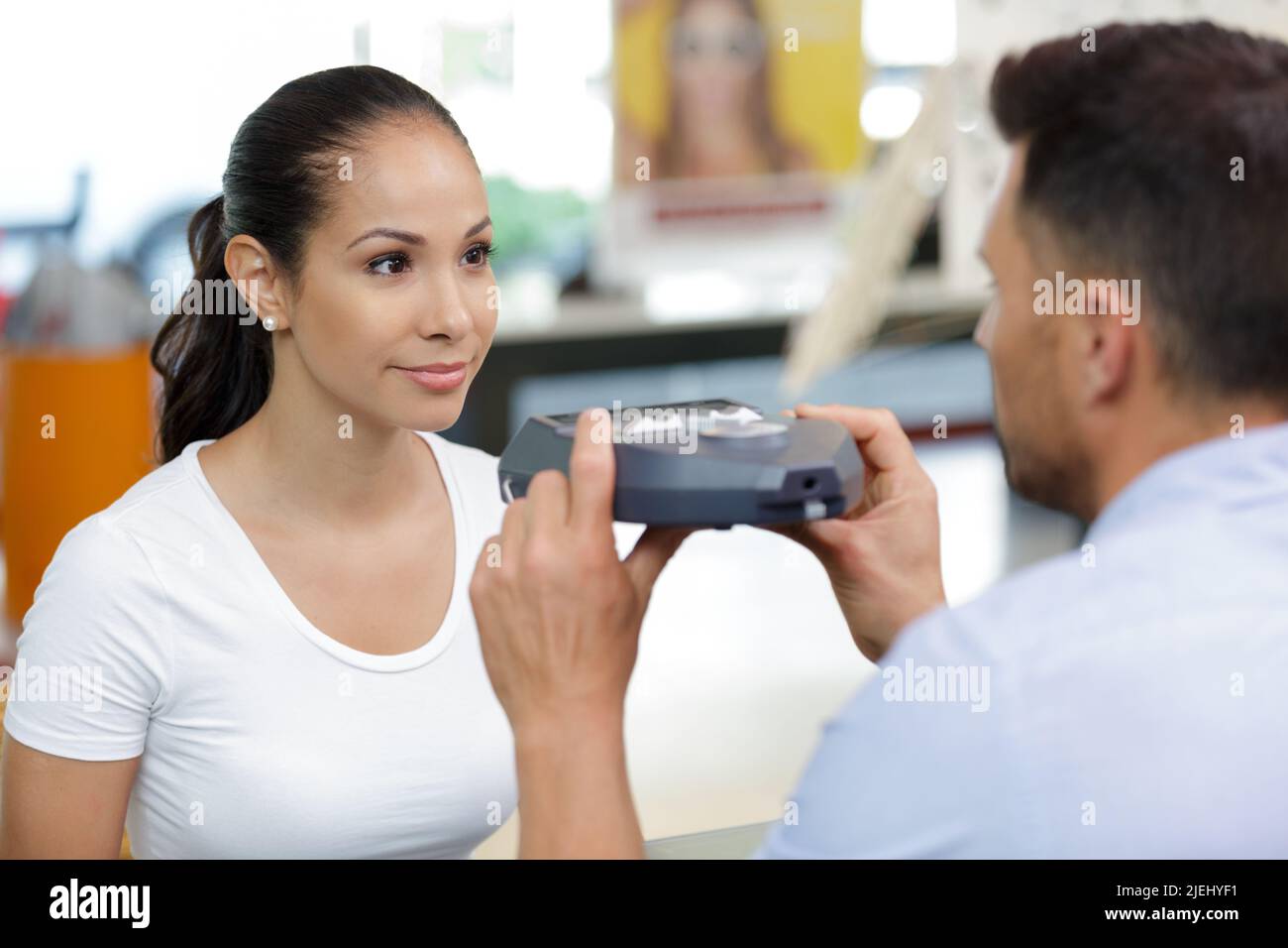 optician preparing to use handheld device to test clients vision Stock ...