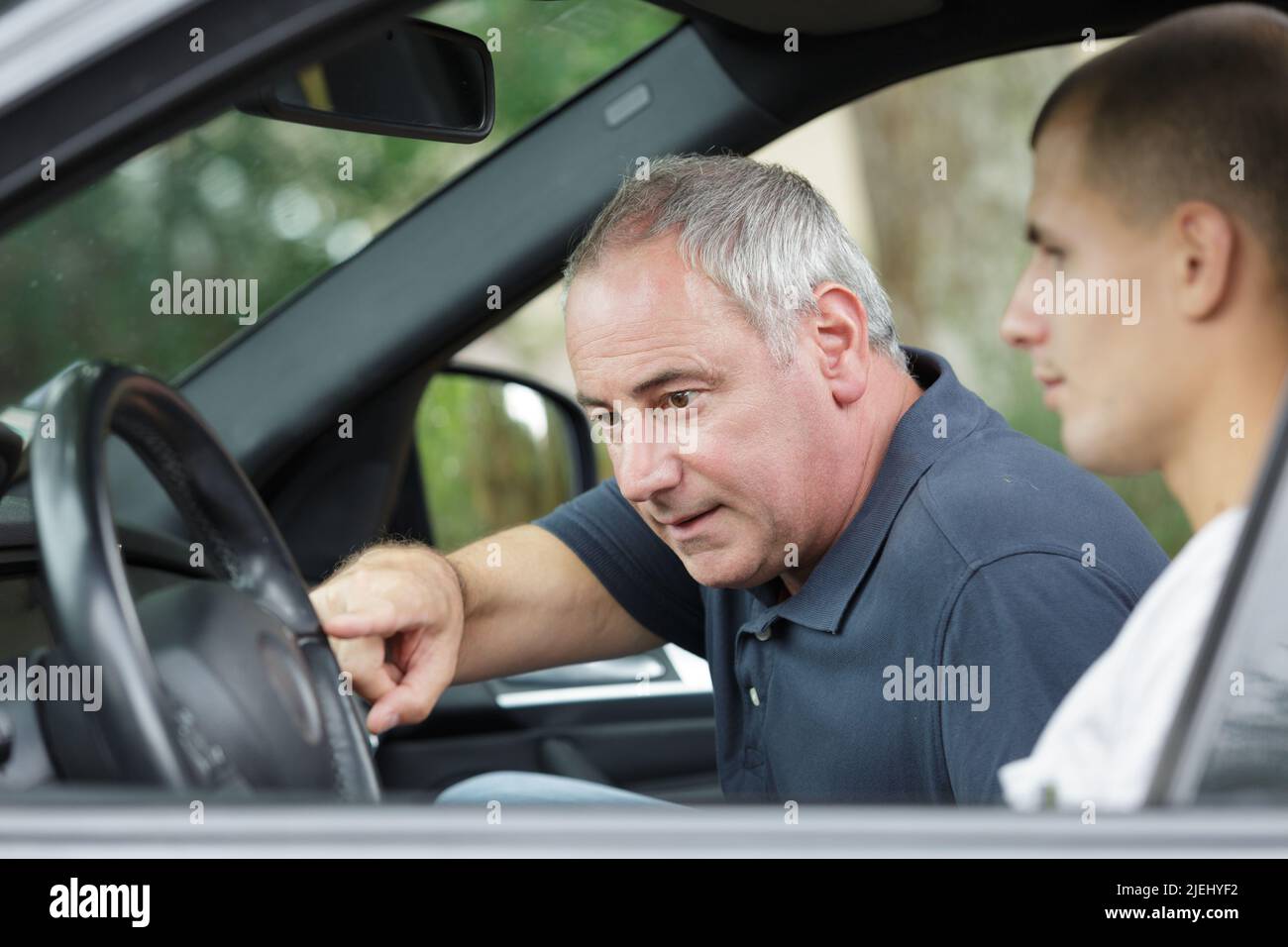 driving teacher showing function buttons to student Stock Photo - Alamy