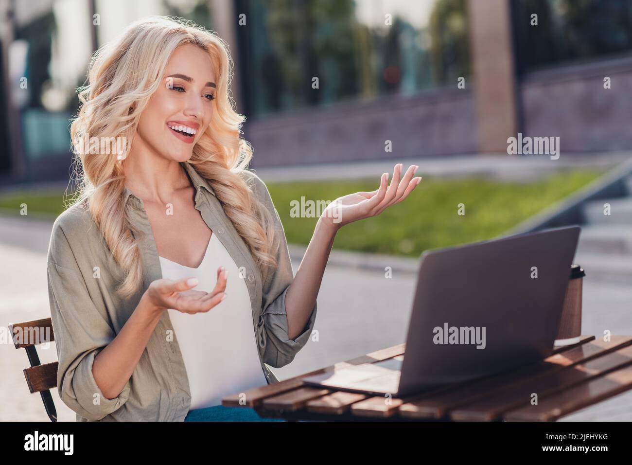 Portrait of attractive cheerful wavy haired girl using netbook calling ...