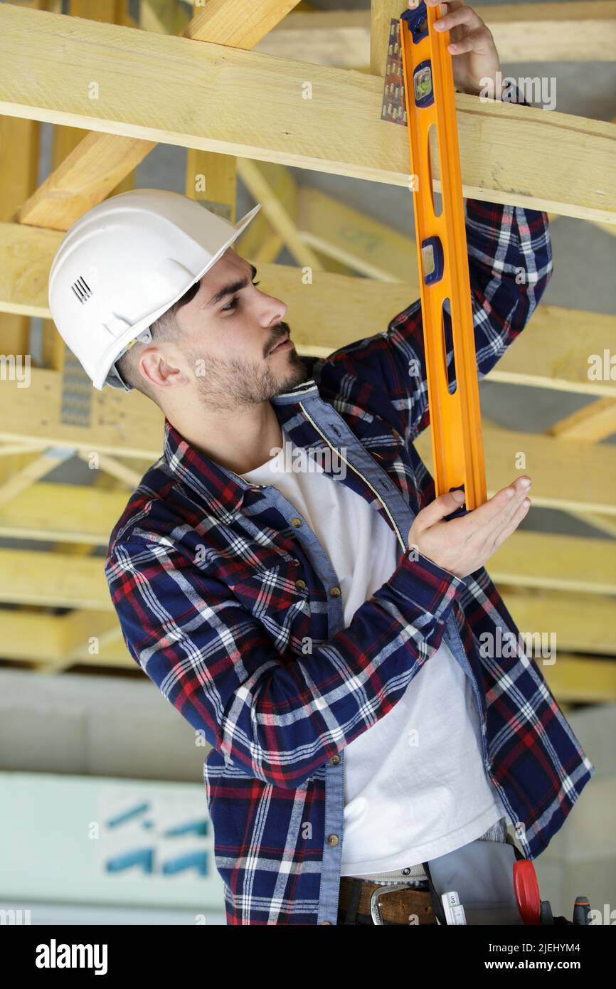 carpenter at work with spirit level on wood structure Stock Photo - Alamy