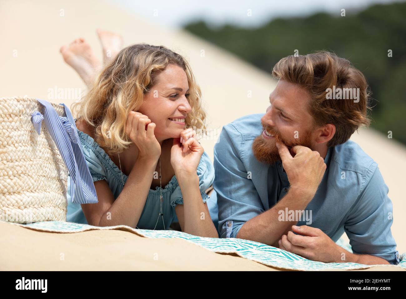 rear portrait of young tourist couple laying together on beach Stock ...