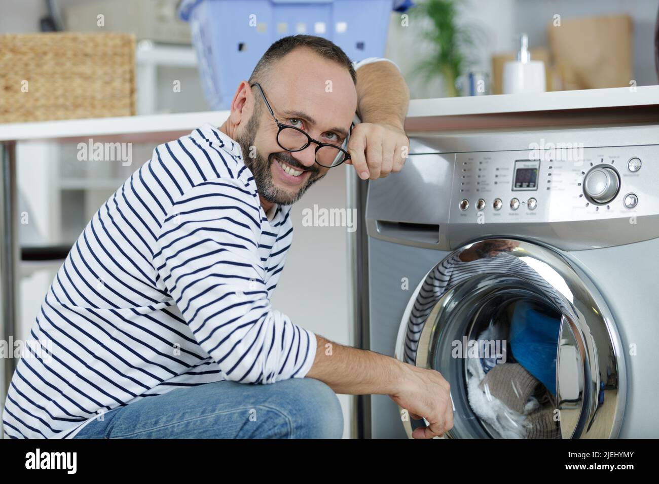 man loading washing machine with clothes Stock Photo - Alamy