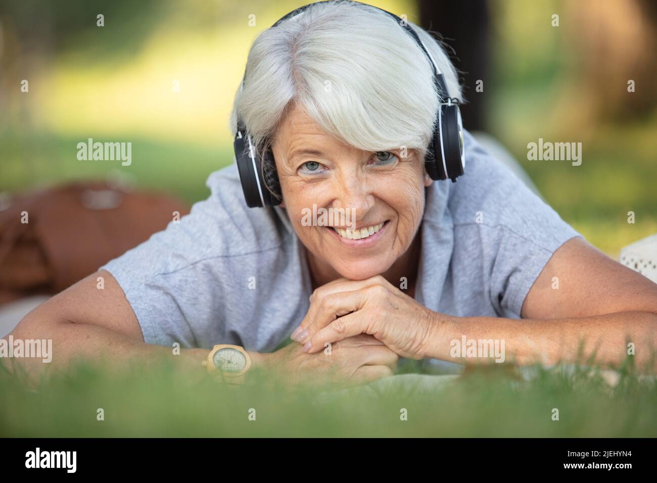 Mature woman enjoys music headphones hi-res stock photography and ...