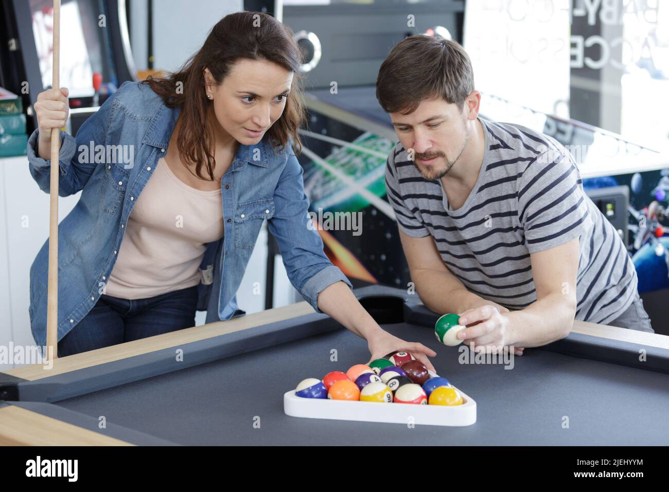 couple setting up balls for a pool game Stock Photo - Alamy