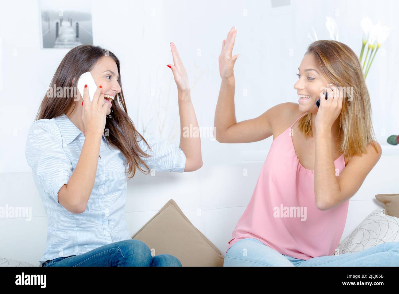 two friends on the phone with high five Stock Photo - Alamy