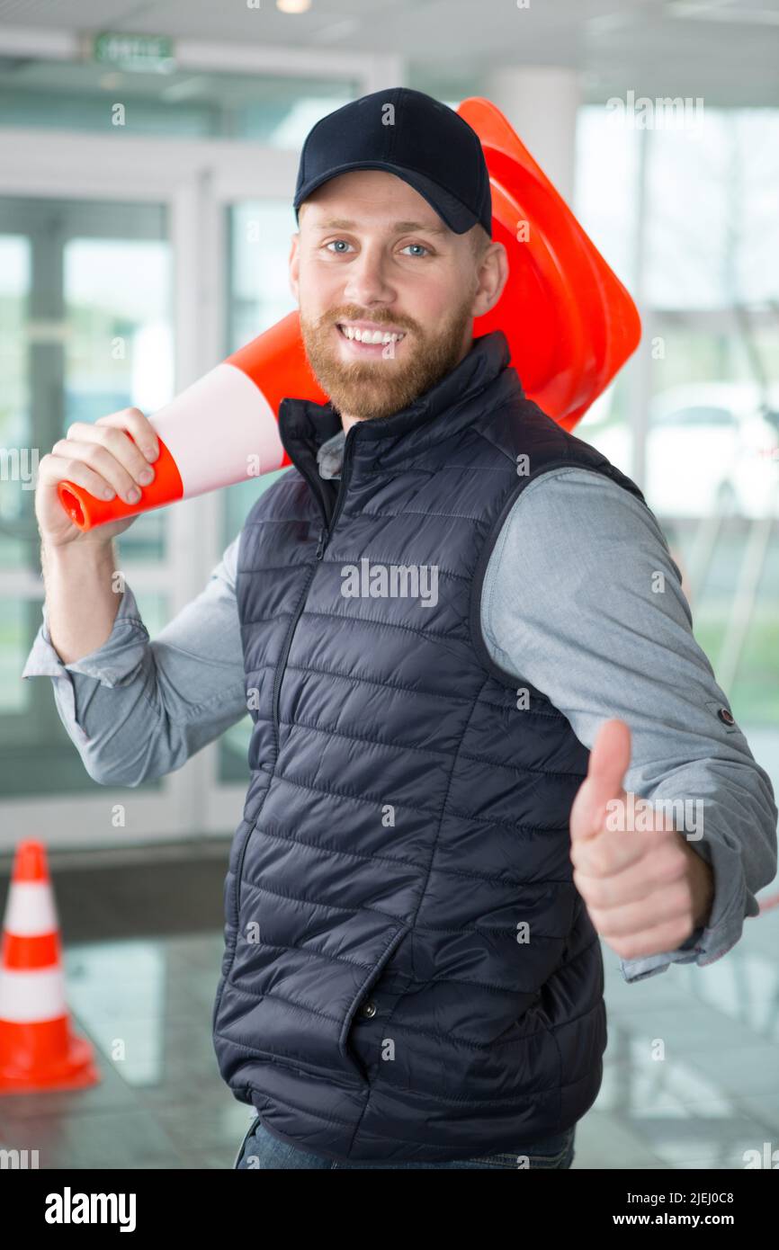 man with safety cone on his shoulder making thumbs-up gesture Stock ...