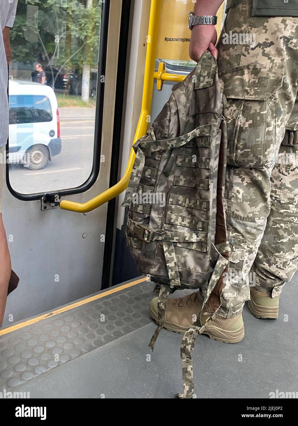 man in military uniform holding backpack in public transport copy space ...