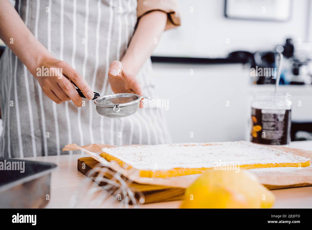 Chefs hands with small sieve for baking. Baker decorating and ...