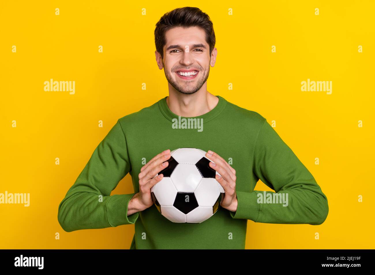 Photo of charming pretty young guy wear green sweater holding football ...