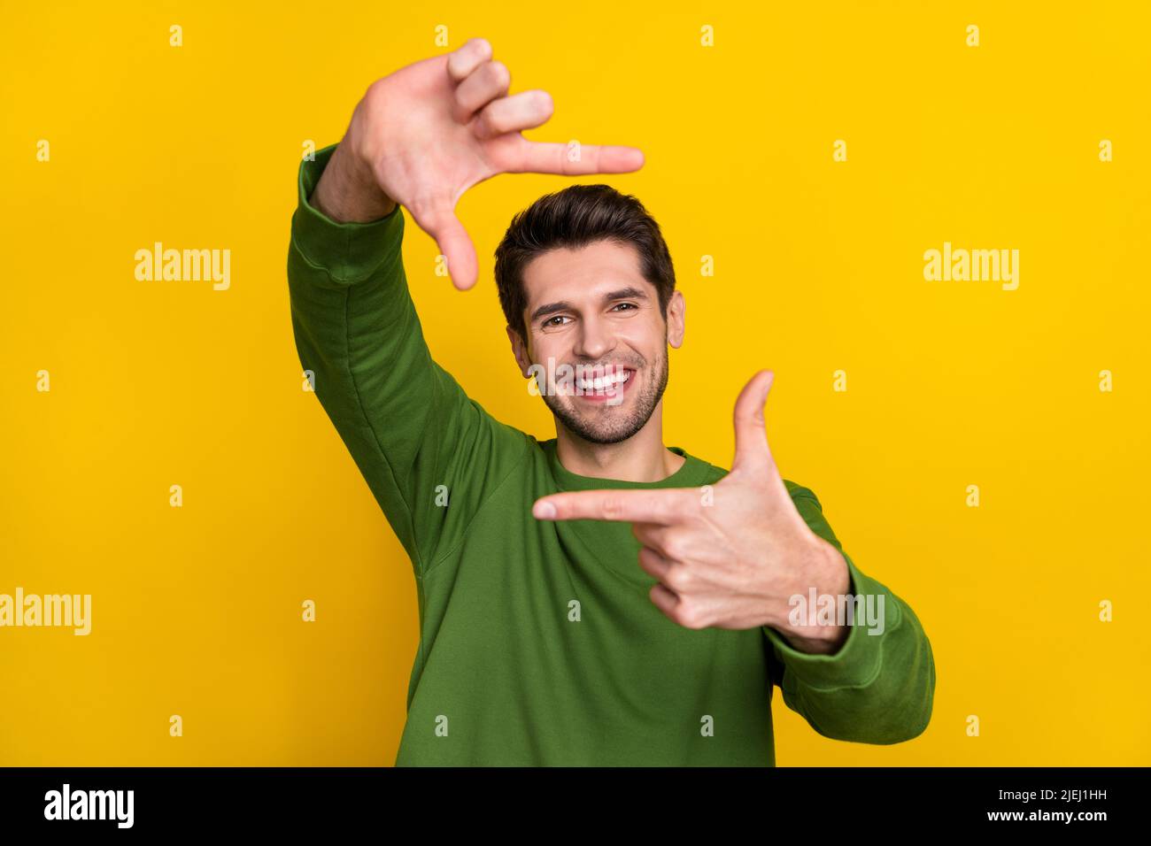 Photo of funny charming guy wear green sweater showing photo shot ...