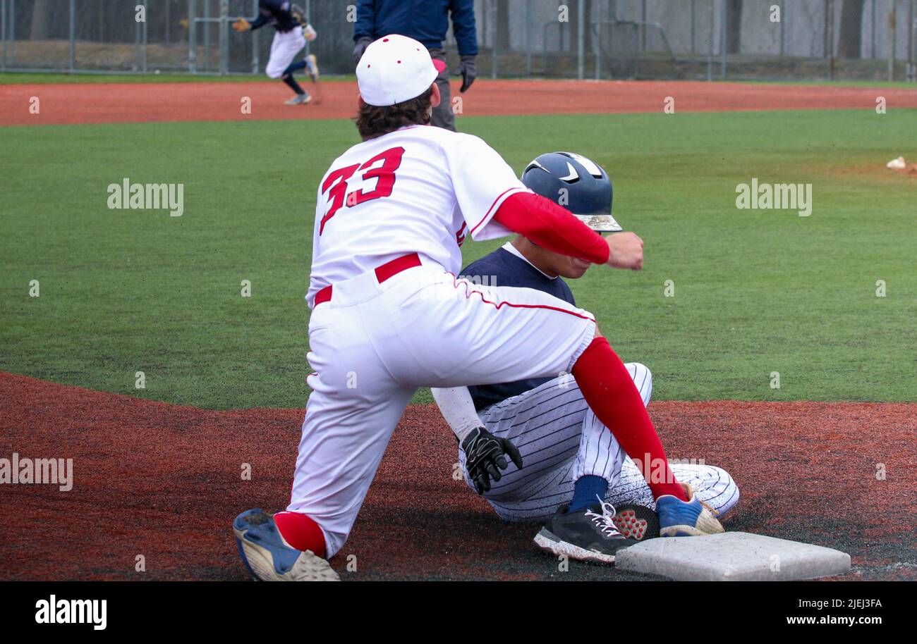 High school baseball player sliding into third base with the third ...