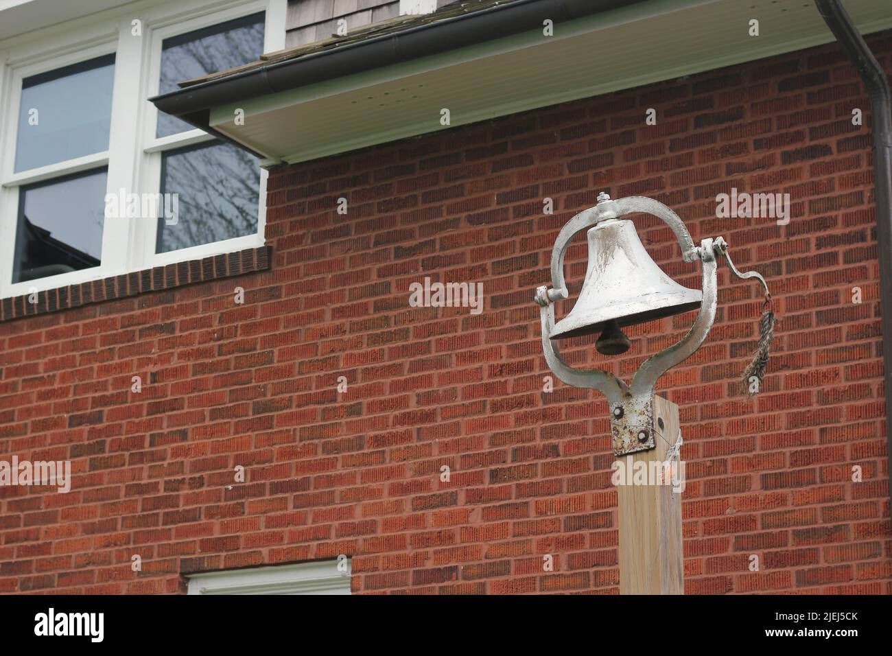 Farm bell mounted on a pole in the farmyard Stock Photo - Alamy