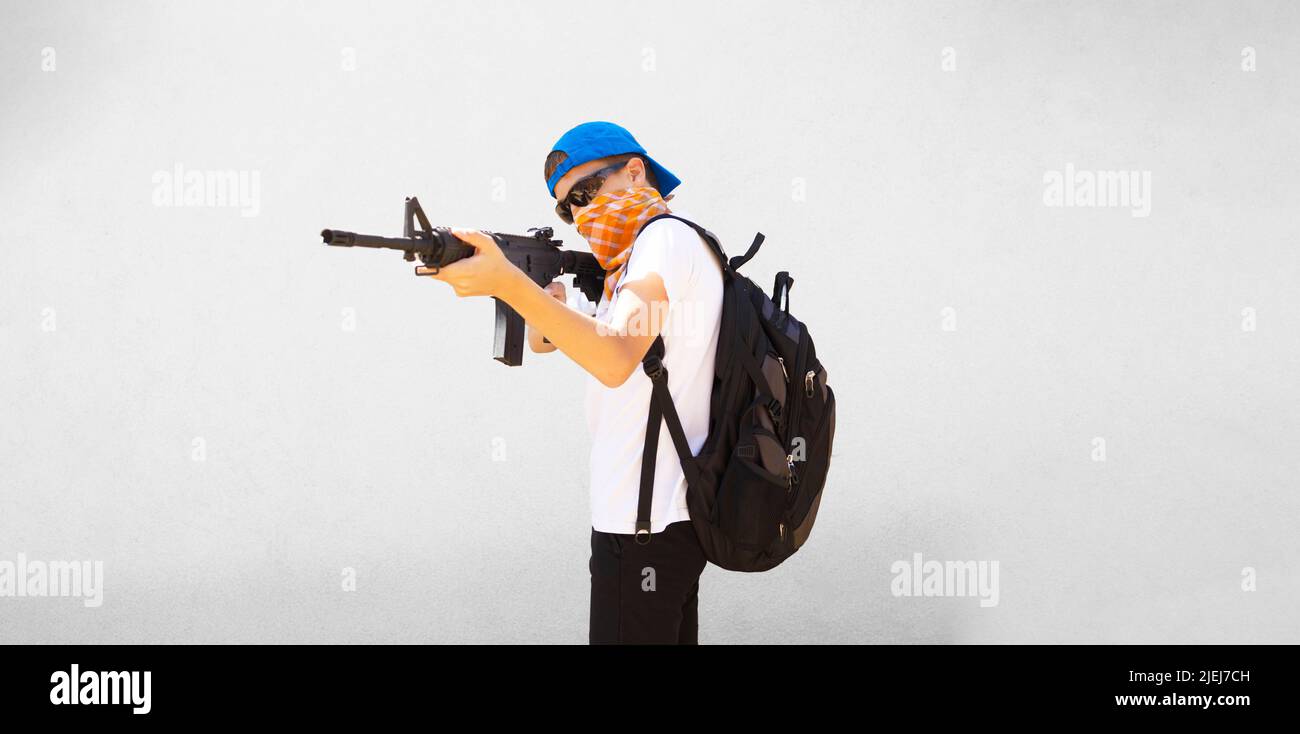 Young man holding a rifle and aiming in the distance. School shooting ...