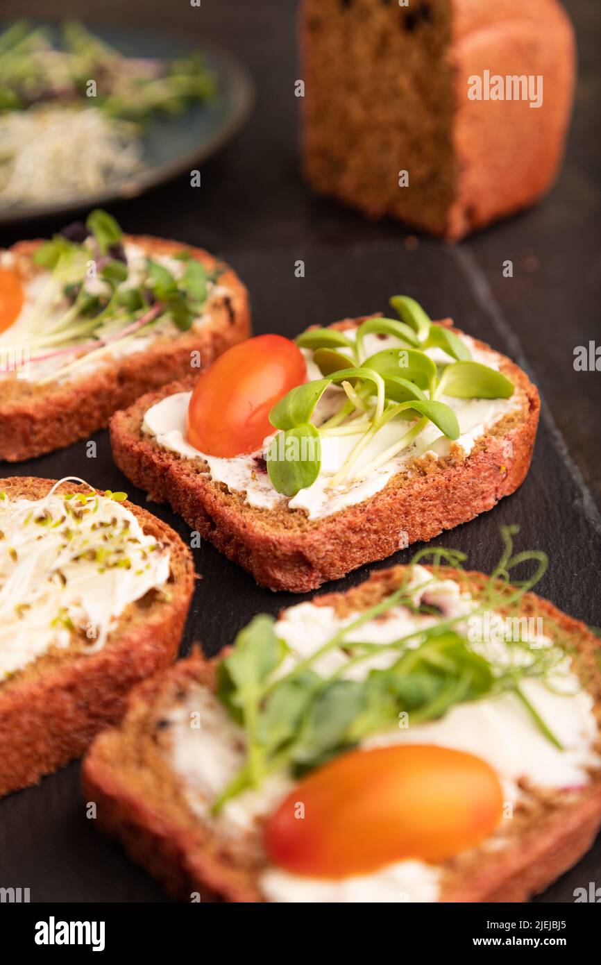Red beet bread sandwiches with cream cheese, tomatoes and microgreen on ...