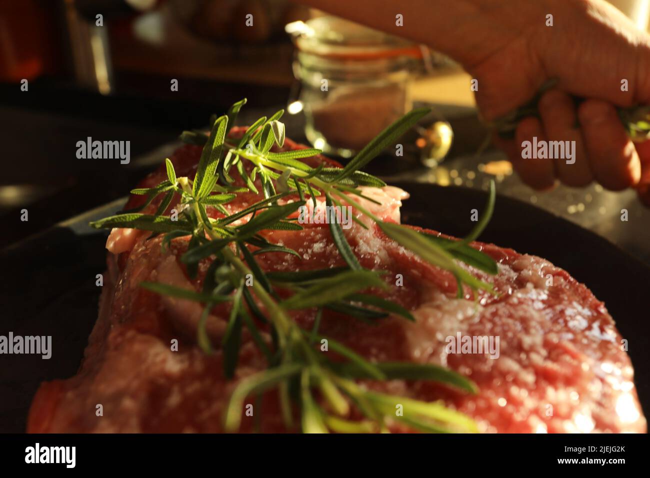 Piece of beef with coarse salt and rosemary ready to go on the BBQ ...