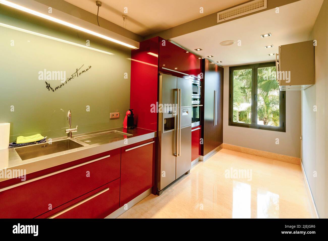 a image of a newly installed red themed kitchen of a apartment along ...