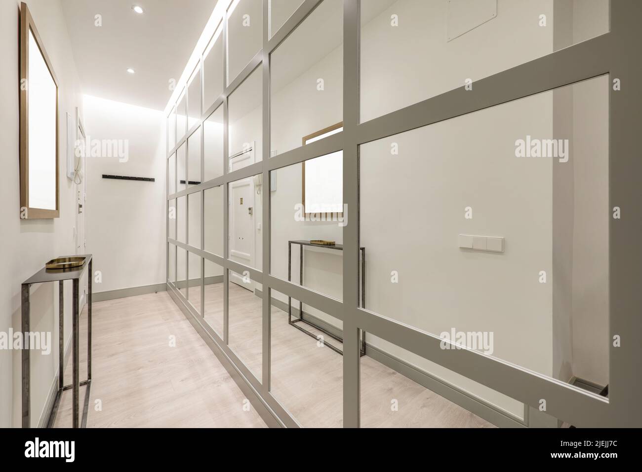 Narrow hallway in a home with an industrial-style appliance and a wall ...