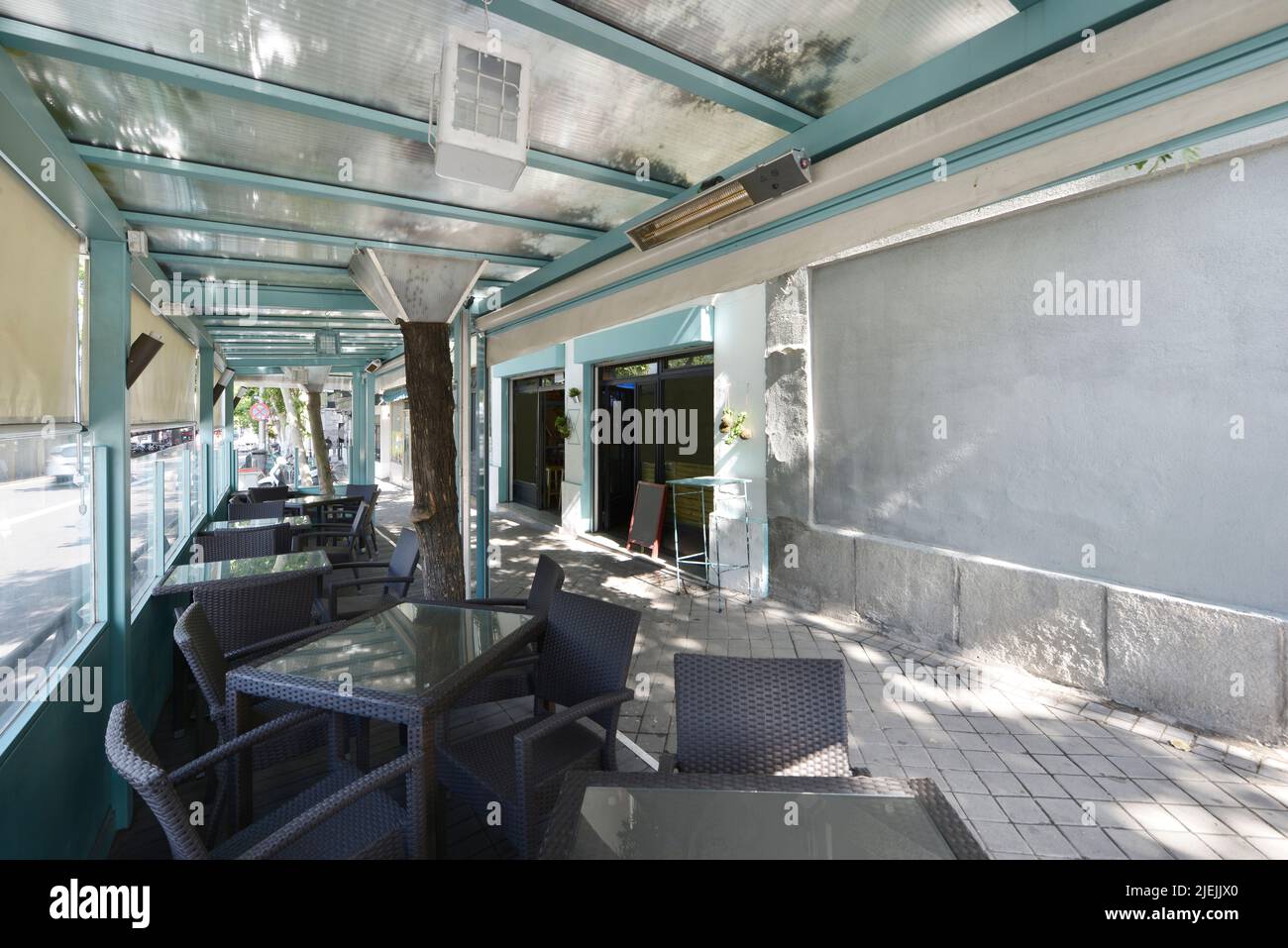 Porch of a light blue restaurant on the sidewalk of a street with ...