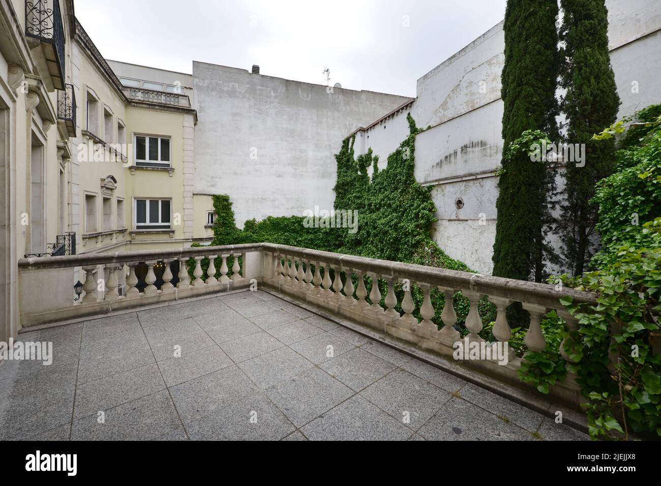 Interior terrace of a palace with climbing plant and cement balustrade ...