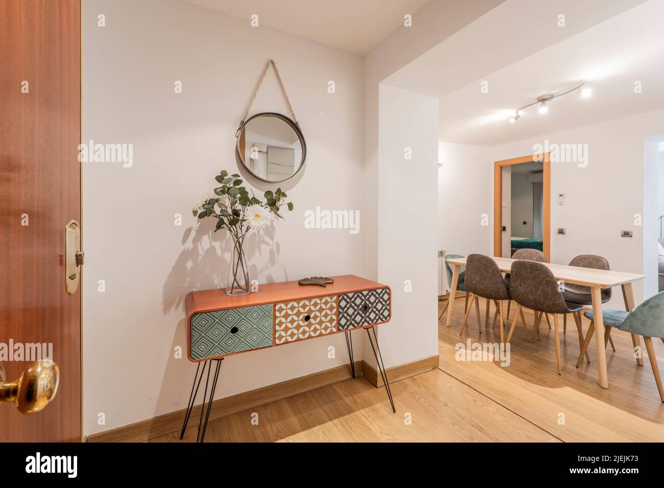 Entrance hall of a house with an orange wooden sideboard with ...