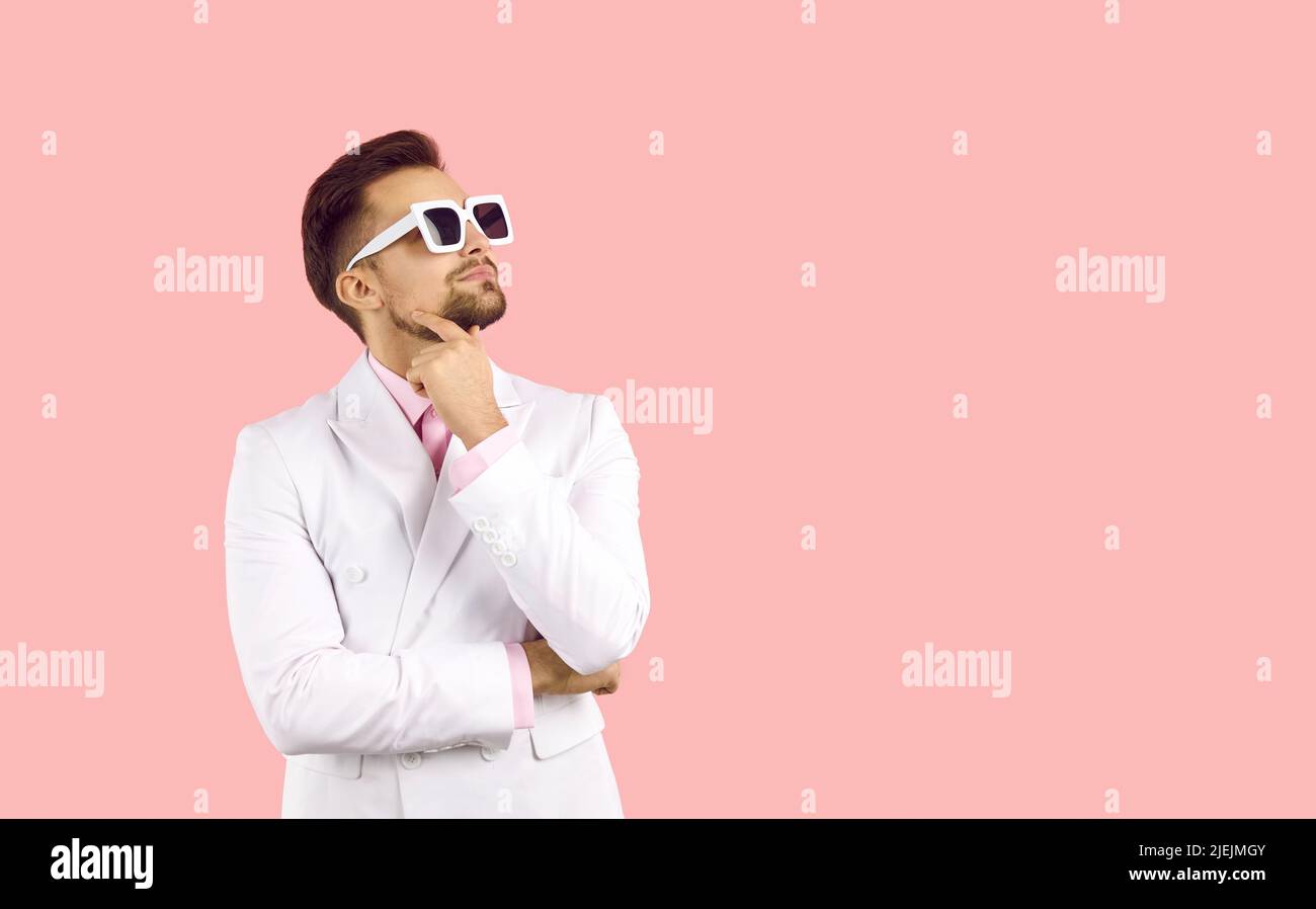 Stylish cool young man with pensive expression thinks about plan or has ...