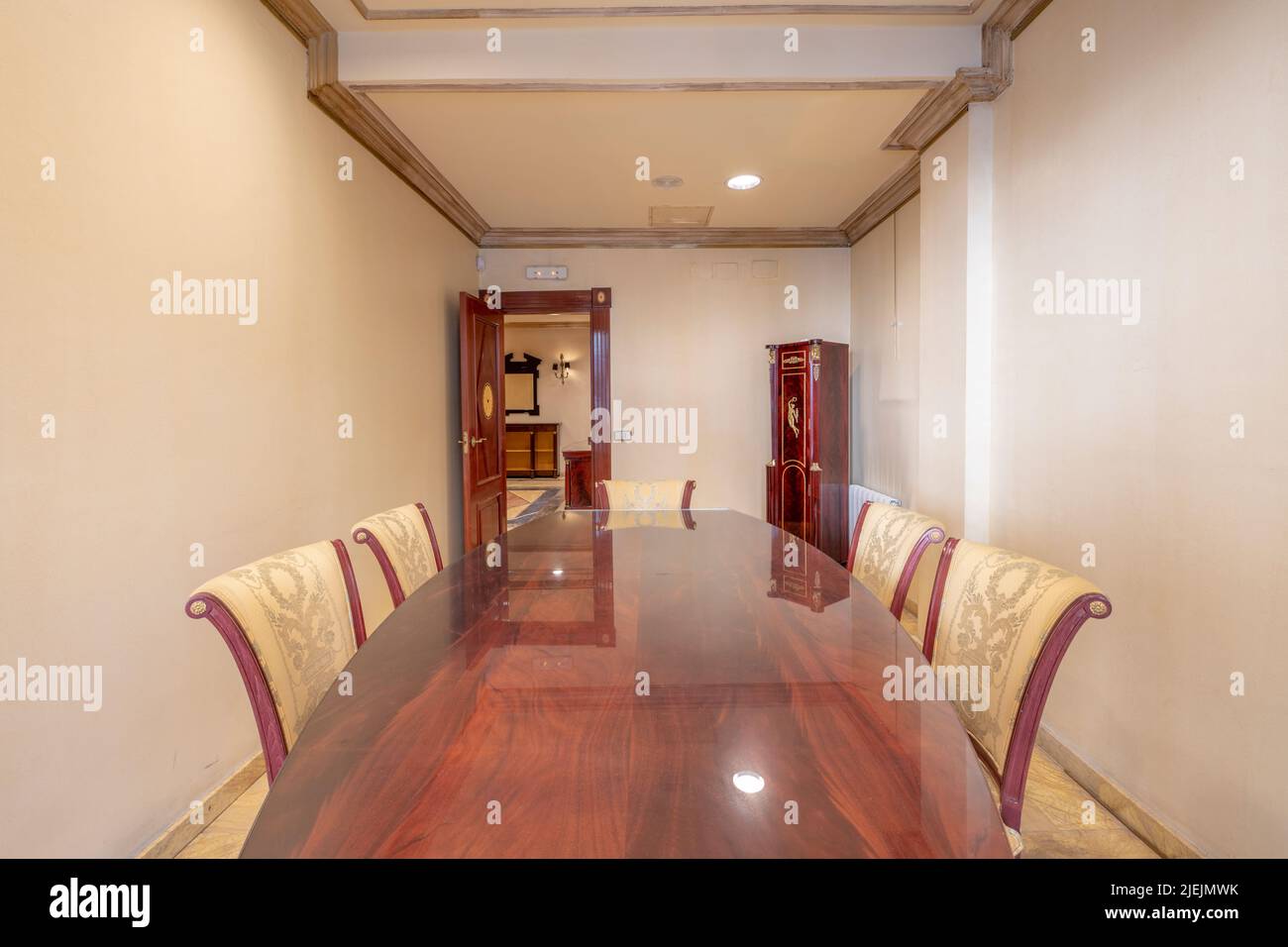 Small meeting room with a shiny wooden table with matching chairs and ...