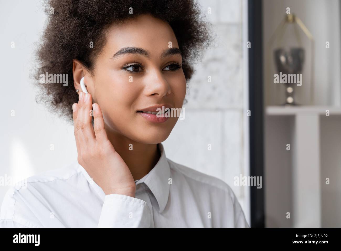 portrait of happy african american woman listening music and adjusting ...