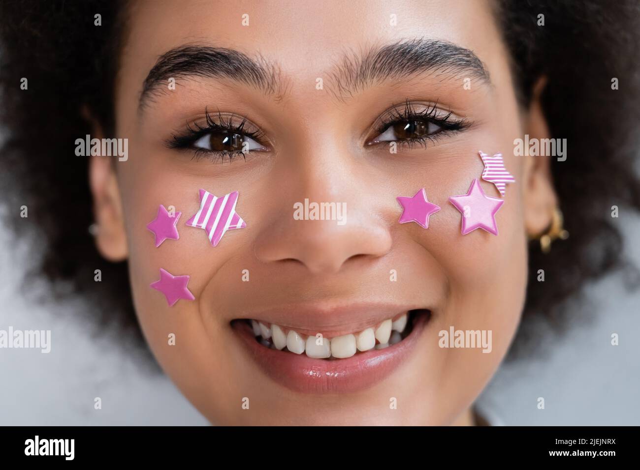 portrait of happy african american woman with decorative purple stars ...