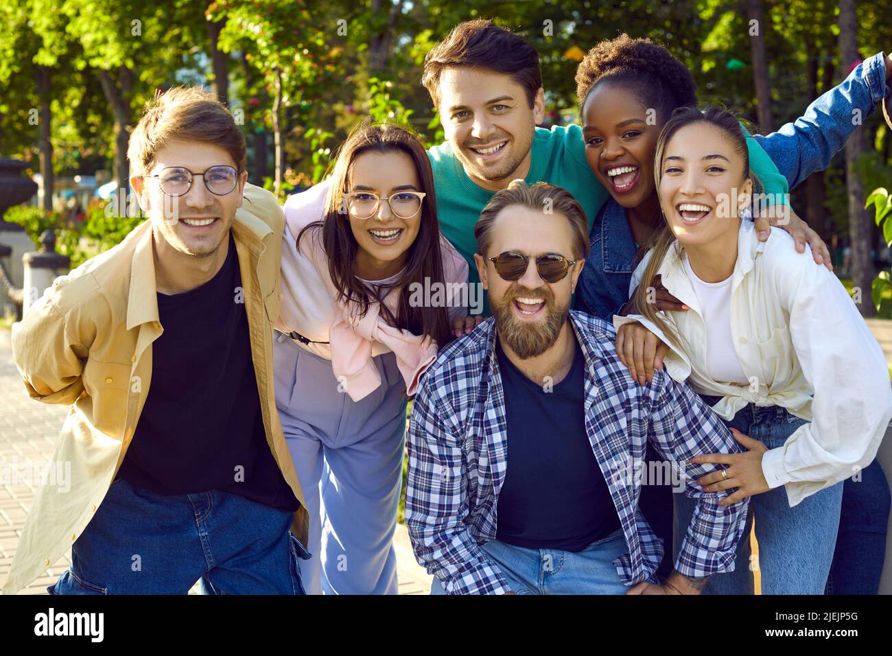 Happy cheerful young multiracial friends posing for a group photo in a ...