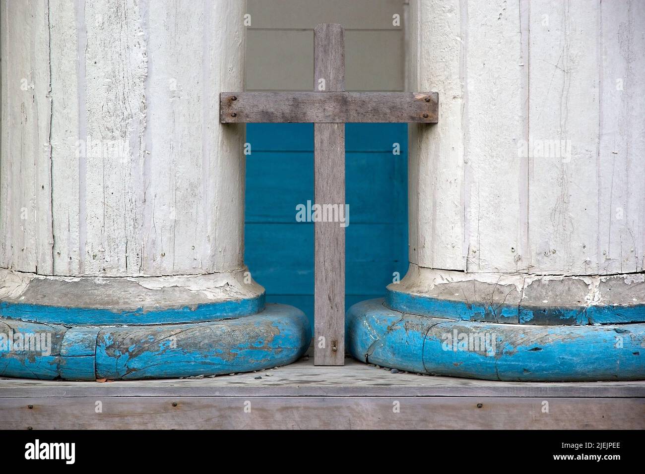 Christian cross among the columns of the facade of the Church of Nercon ...