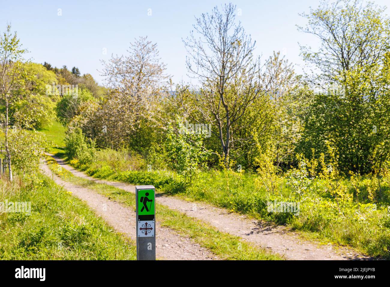 Hiking trail sign by a dirt road in a rural landscape Stock Photo - Alamy