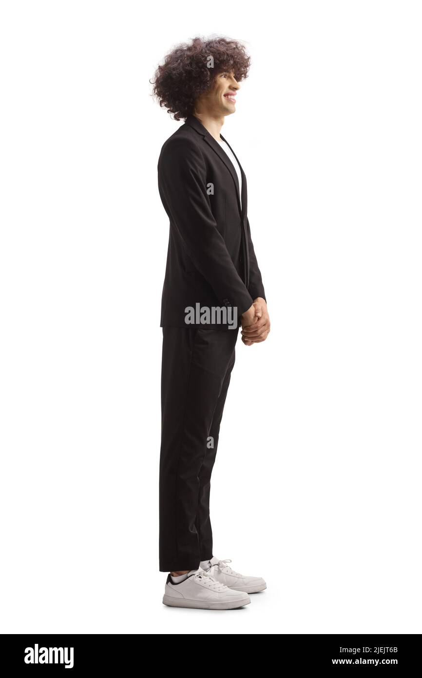 Full length profile shot of a smiling young man in a black suit ...