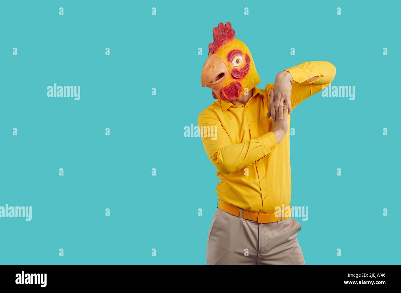 Cheerful funny man in rubber mask of chicken head has fun during ...