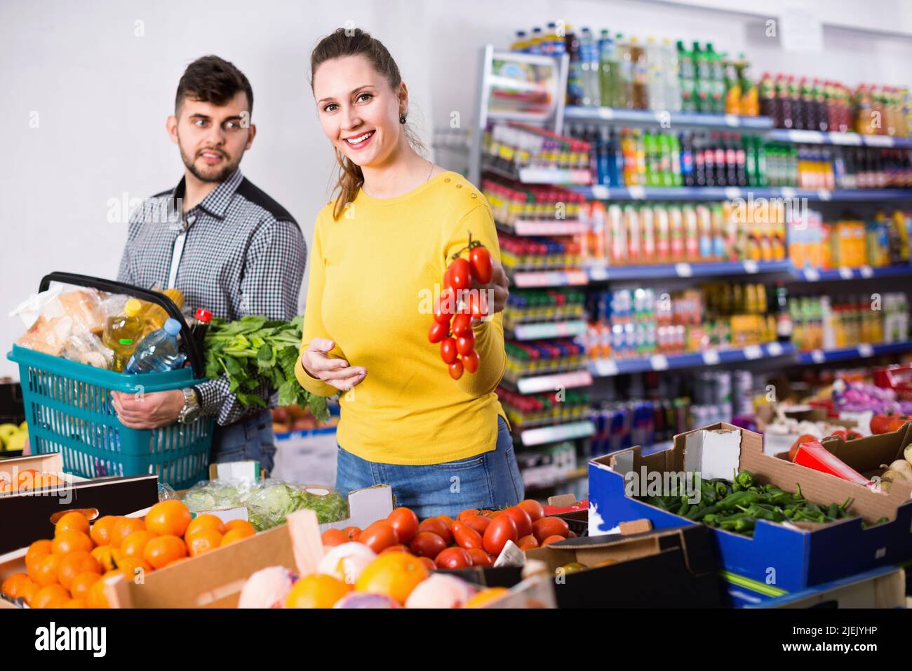 Positive couple choosing fresh vegetables in vegetable department Stock ...