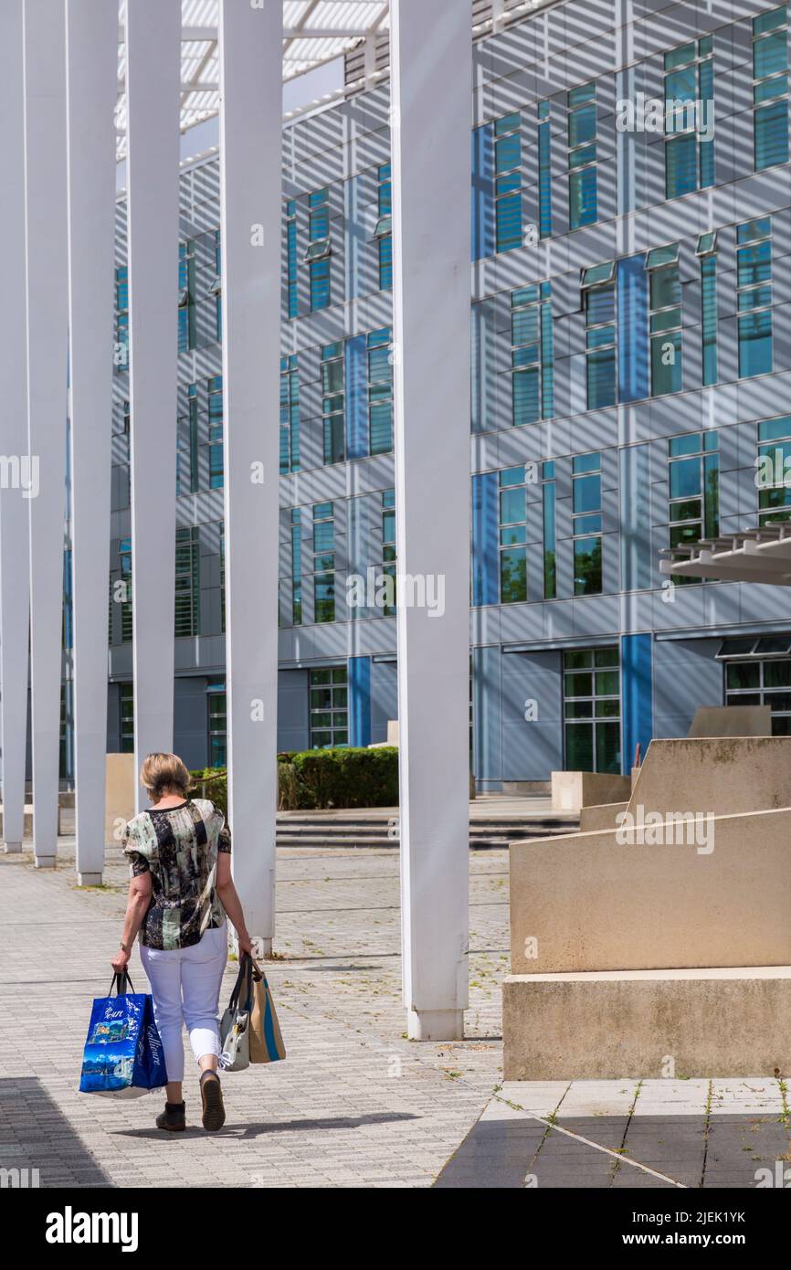 Woman carrying shopping bags walking past The Quadrant building at ...