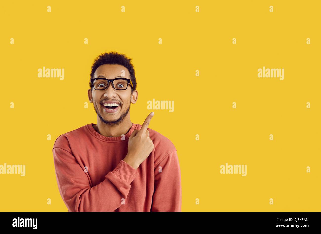 Happy excited university student pointing his finger to the side on ...