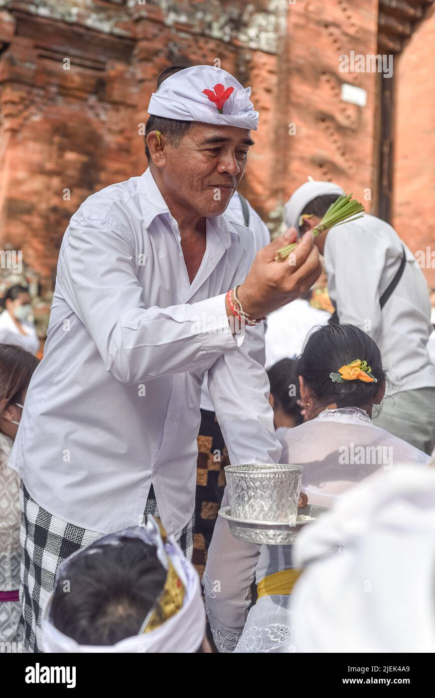 A Hindu religious leader splashes holy water on devotees during the ...
