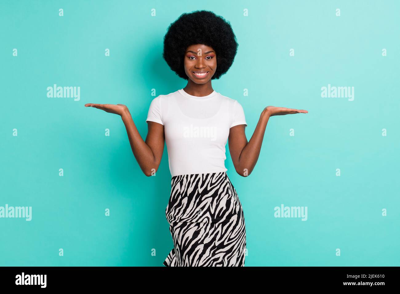 Photo of happy nice positive dark skin woman hold hands empty space ...