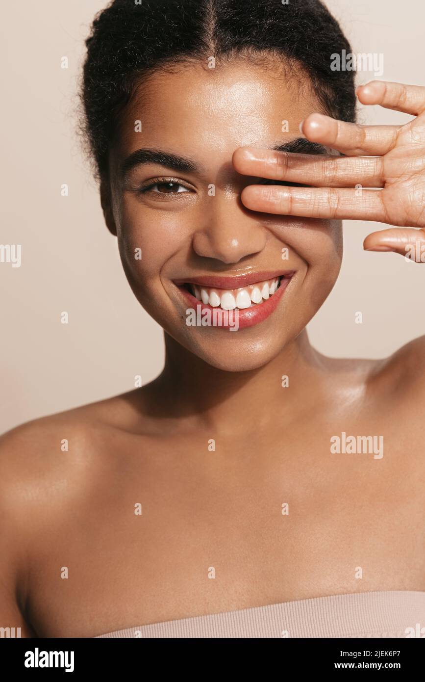 Vertical of dark skinned model shows her glowing, clear natural facial ...