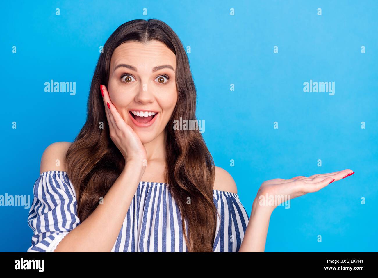 Photo portrait woman showing copyspace keeping on palm smiling amazed ...