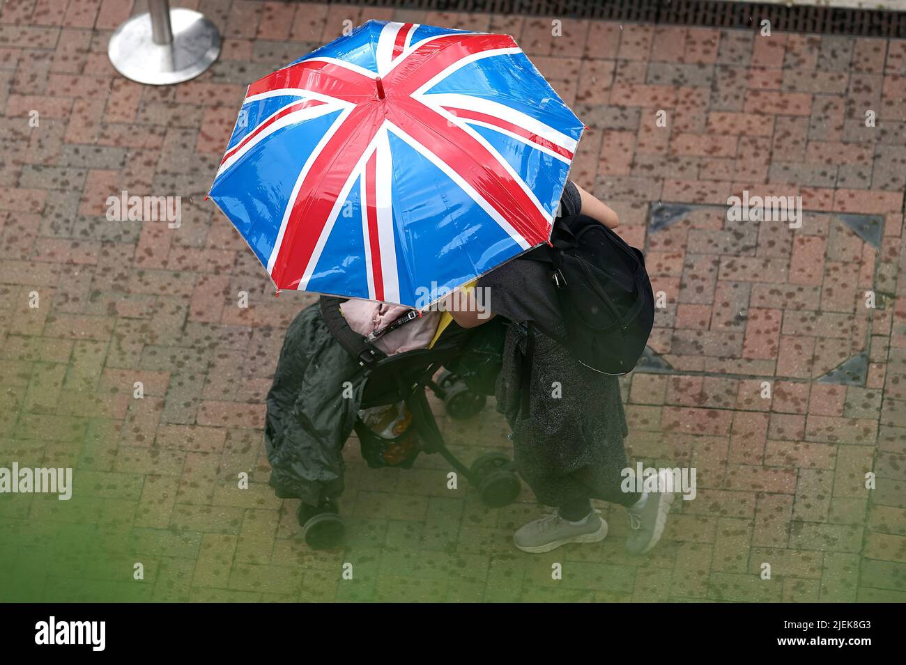 Spectator shield themselves from the rain with a Union Jack umbrella ...
