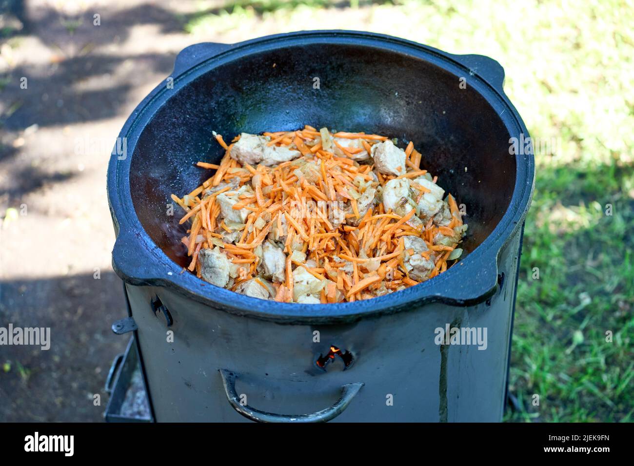 Cooking pilaf in a cauldron on fire in the garden Stock Photo - Alamy