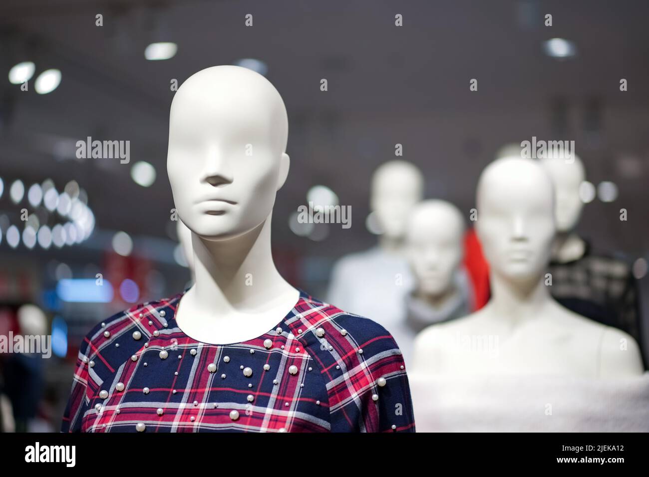 Female mannequins are dressed in casual clothes with a red-orange theme ...