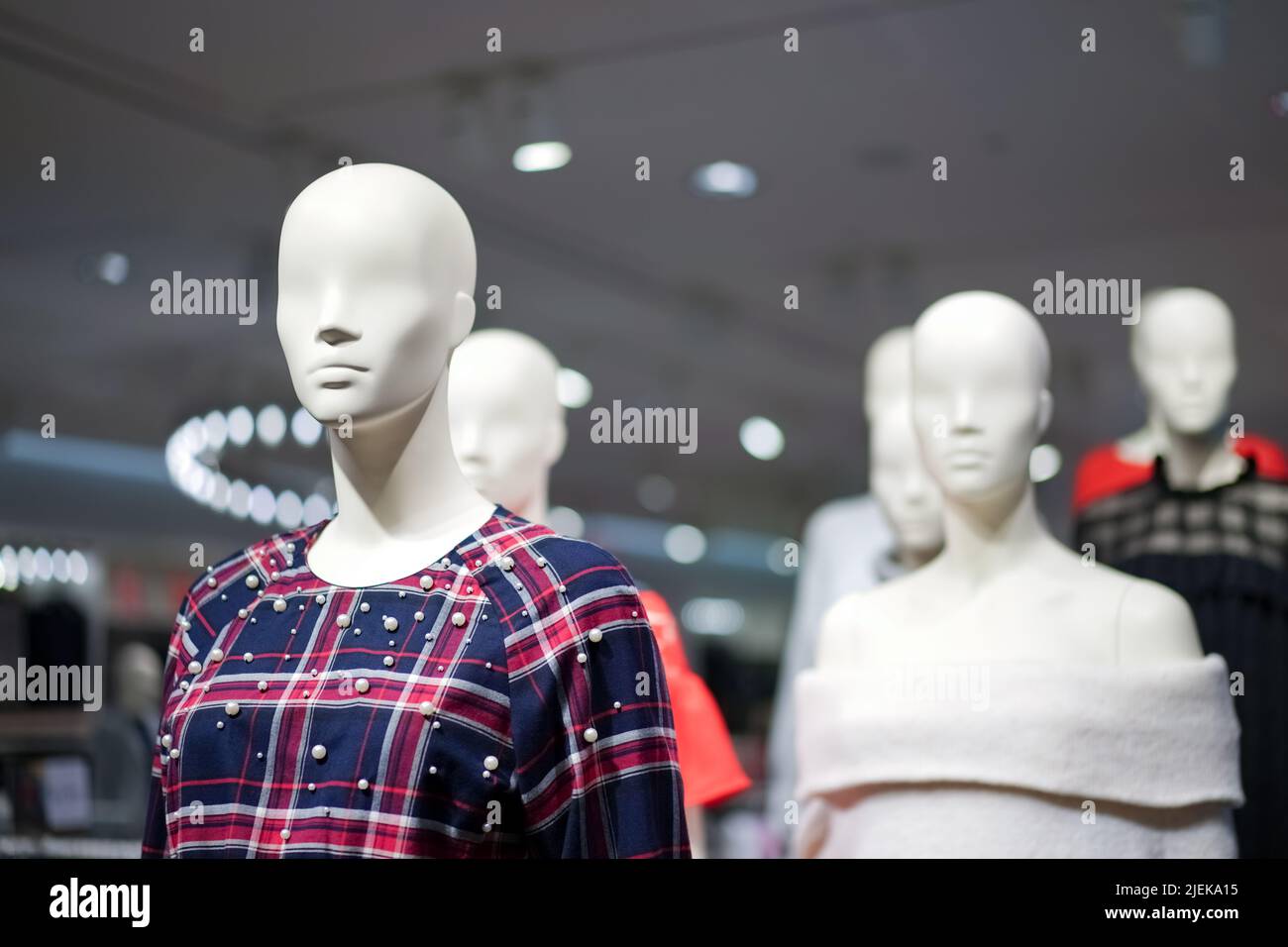Female mannequins are dressed in casual clothes with a red-orange theme ...