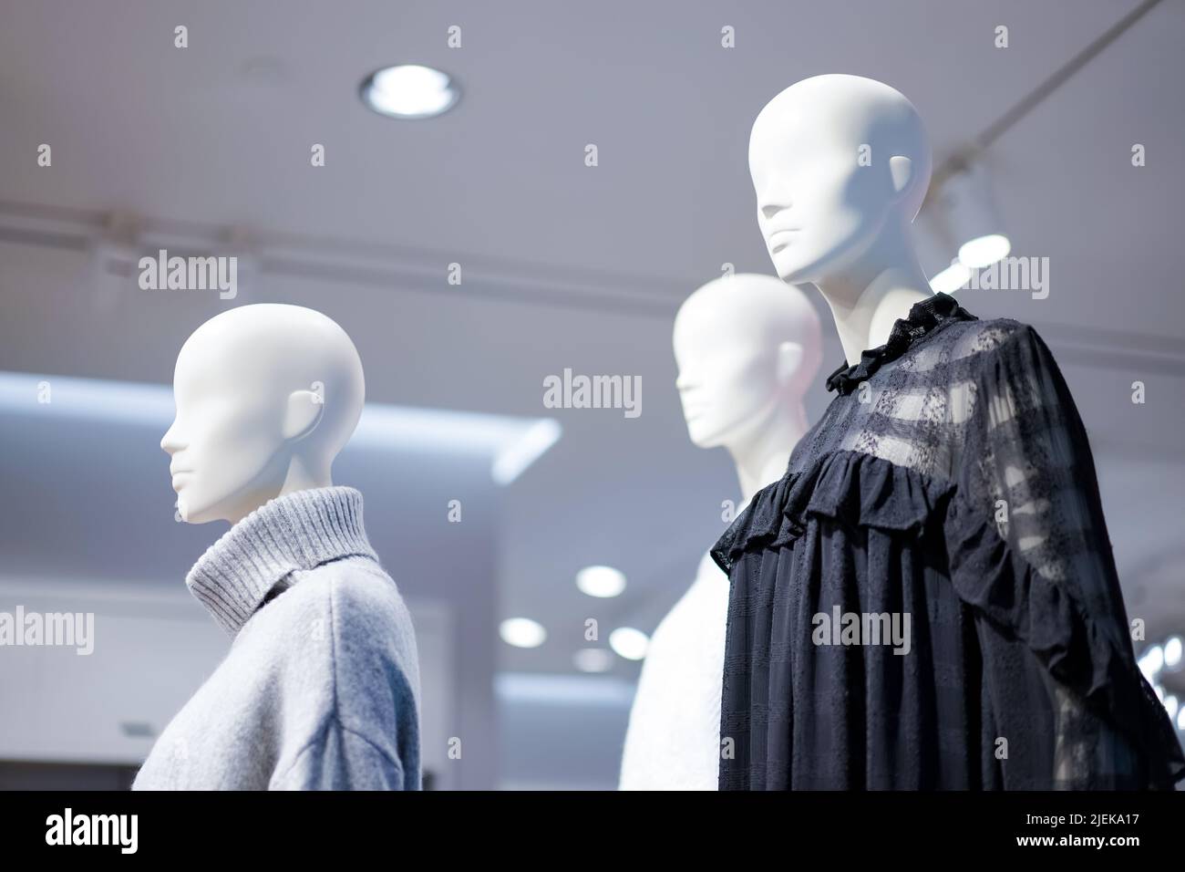 Female mannequins are dressed in casual clothes with a red-orange theme ...