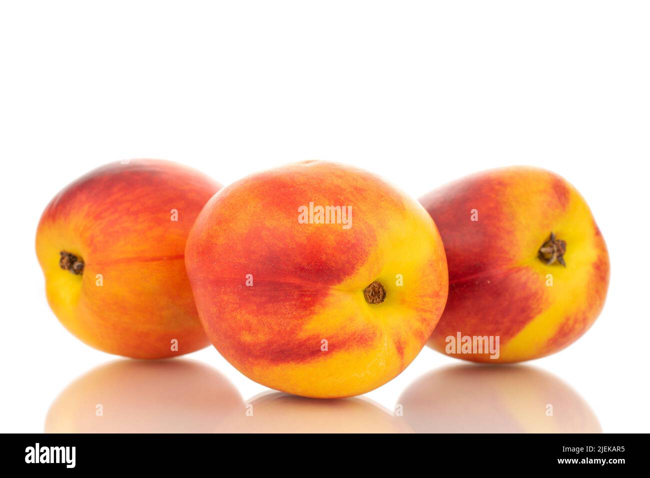 Three juicy organic nectarines, close-up, isolated on white background ...