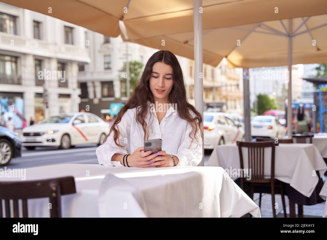 Woman sitting waiting at table in outdoor restaurant cafe. Female ...