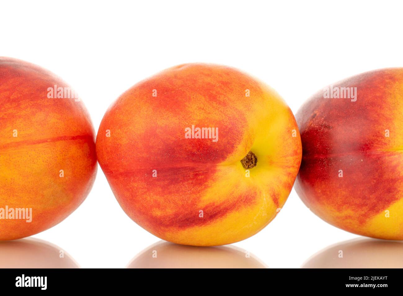 Three juicy organic nectarines, close-up, isolated on white background ...