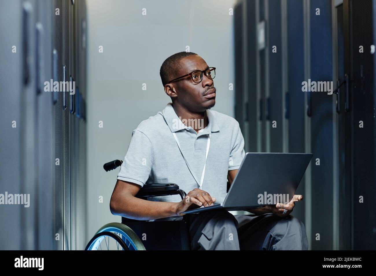 Minimal portrait of young black man with disability using laptop in ...