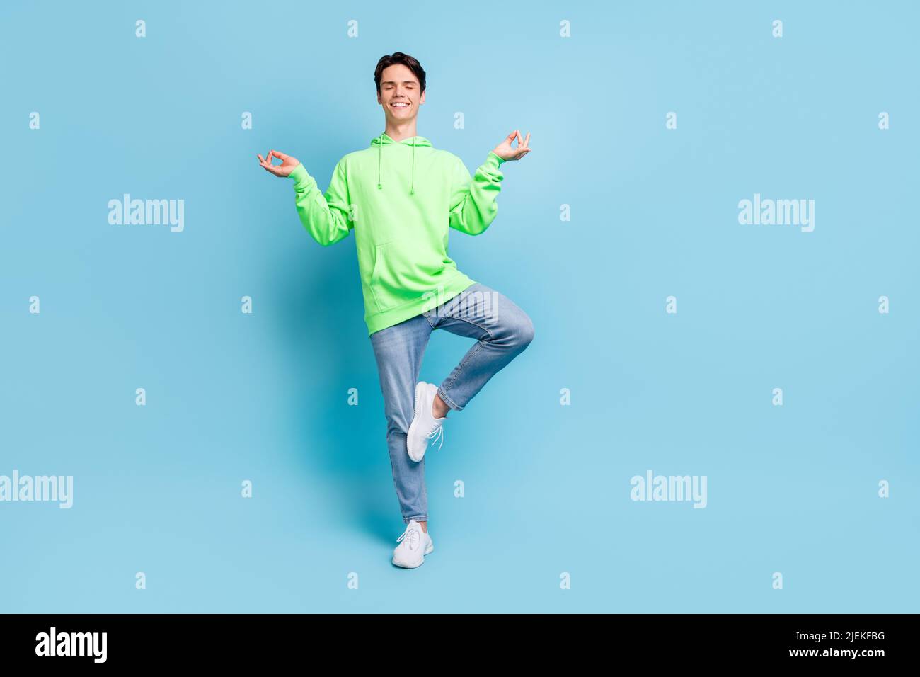 Photo of peaceful dreamy guy meditate close eyes stand one leg wear ...